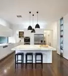 Juodųjų pakabukų lempų grupė ant baltos virtuvės