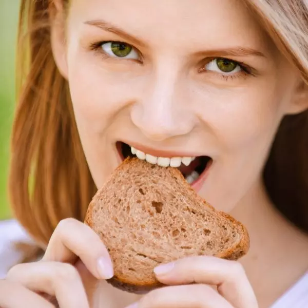 Menina come pão fresco