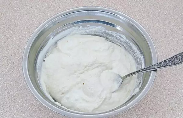 ஒரு உலோக தொட்டியில் Semolina மற்றும் புளிப்பு கிரீம் ஒரு கலவையை