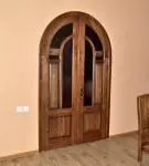 Łukowate drzwi w połączeniu z drewnianymi meblami