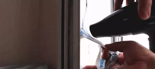 Radnik uklanja film sa građevinskim sušilom za kosu