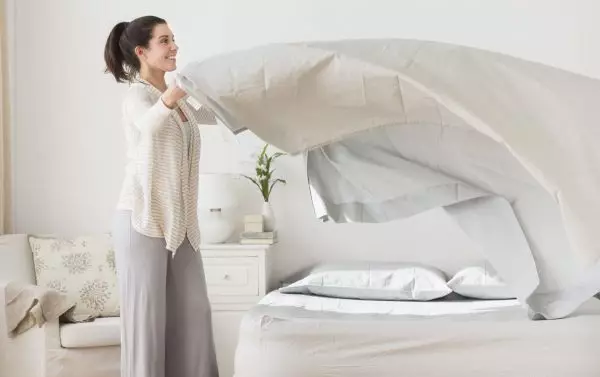 Kvinna fyller en säng