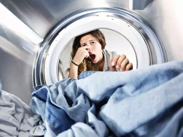 Pige tilslut næsen, kigger ind i vaskemaskinen