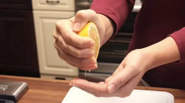 Jus membagi lemon menetes di telapak tangan