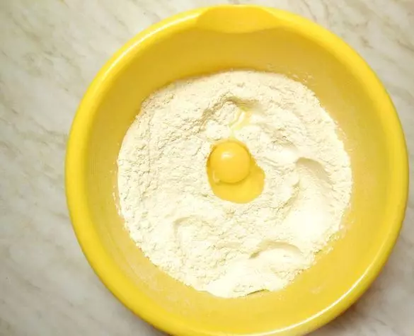 Surové vajcia v žltej miske s múkou