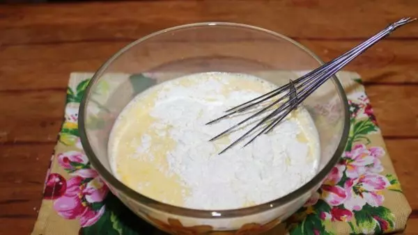 آرد در یک کاسه با مخلوط تخم مرغ شیر