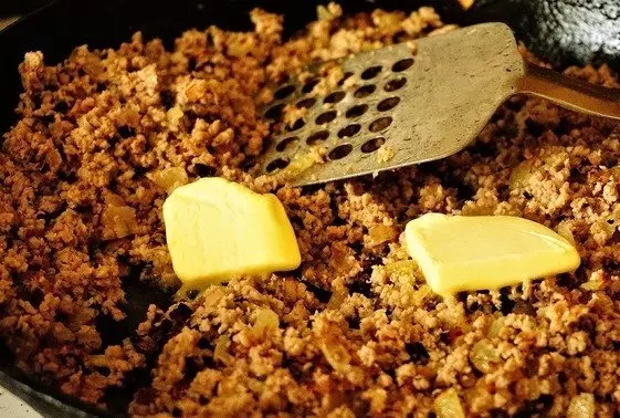 Butterscheiben in einer Bratpfanne mit Hackfleisch