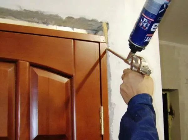 העובד מחלק את הפער בין מסגרת הדלת לבין הקיר
