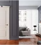 Baltās durvis uz pelēka sienas fona