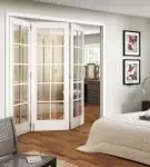 Bīdāmās baltas durvis dzīvojamās istabas interjerā