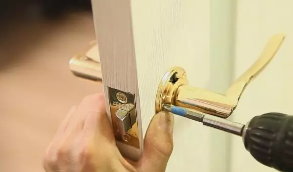 Een handvat op een metalen deur installeren