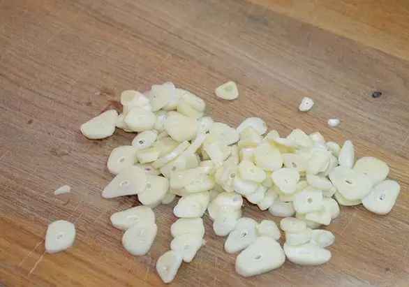 Sliced ​​with thin plates garlic on a cutting board