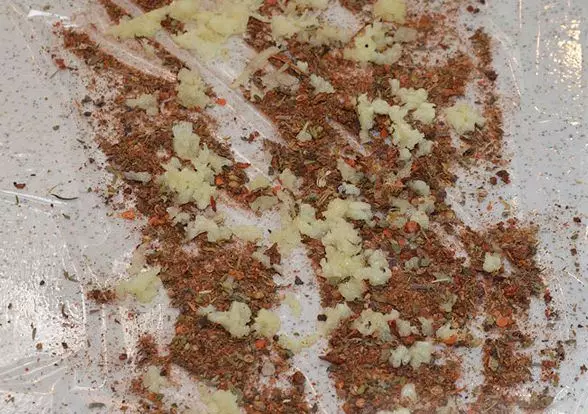 Potravinářský film pokrytý sekaným česnekem a kořením