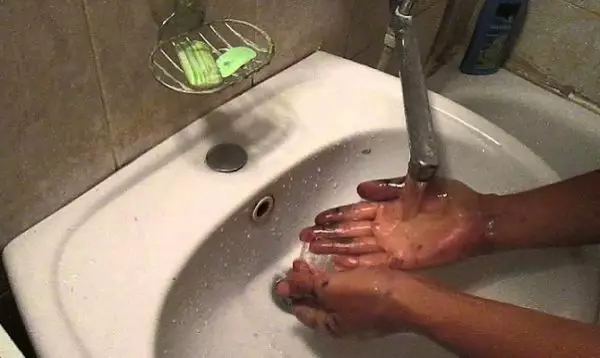 Τα χέρια στο mangartage πλένουν στο νεροχύτη