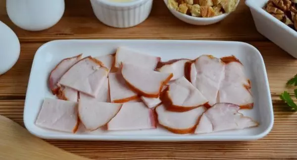在一个白色长方形沙拉碗的切的熏制的鸡胸脯在桌上