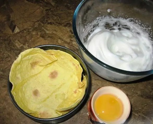 Pişirme formunda lavash, çırpılmış sincaplar ve çiğ yumurta sarısı ile kase