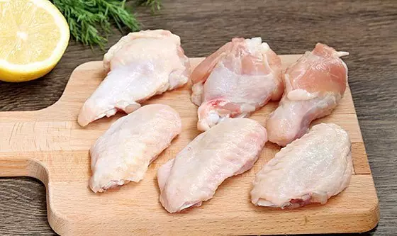 Pezzi di ali di pollo su un tagliere di legno