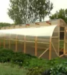 Arched greenhouse of wood and polycarbonate with functional roof