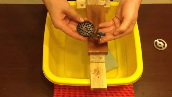 একটি গ্রাইন্ডিং স্টোন উপর মাংস grinder জন্য ছুরি sharpening