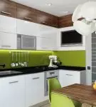 绿色围裙在有白色家具的厨房里