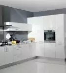 Λευκά έπιπλα στο φόντο των γκρίζων τοίχων κουζίνας
