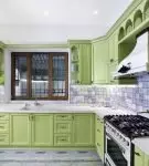 Vitt tak och gröna möbler i köket