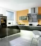 Orange væg i køkkenet med mørke møbler