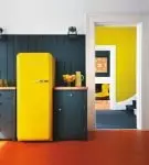 Réfrigérateur jaune sur un fond sombre dans la cuisine rétro