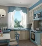 Blauwe gordijnen en gevels van meubels in de keuken