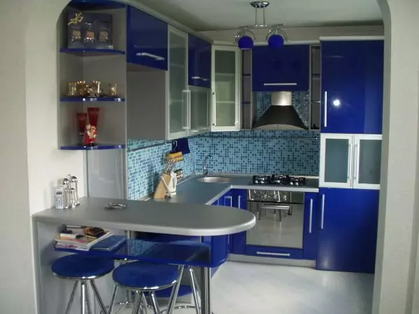 Blå hodetelefoner og blått forkle på kjøkkenet