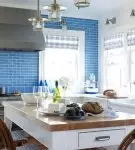 रसोई में उज्ज्वल नीली दीवार और सफेद फर्नीचर