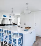 एक बड़ी रसोई में सफेद कुर्सियां ​​और नीले भागों