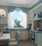 Blauwe gordijnen en tweekleurige meubels in de keuken