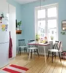 नीली दीवार के साथ रसोई में सफेद फर्नीचर