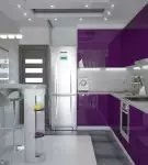 Piccola cucina con mobili bianchi-viola e sedie insolite