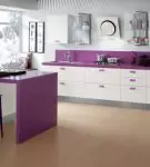 Auriculares brancos e avental roxo em uma grande cozinha