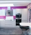 Mobili bianchi sullo sfondo della parete della cucina viola