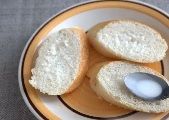 Segmenten van stokbrood op een plaat en melk in een lepel