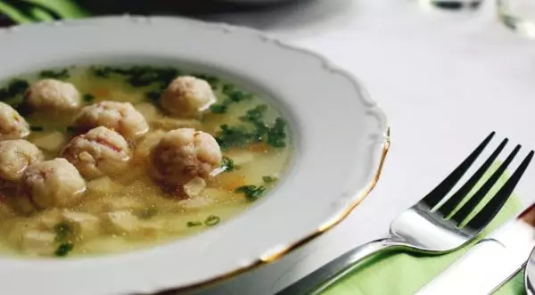 Zupa z klopsikami i zielonymi cebulami w płytce porcji