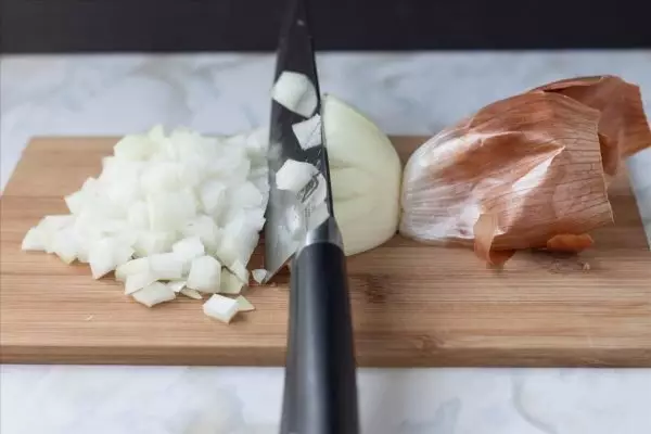 Onions prerë në një bord prerës