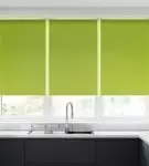Rollierte grüne Vorhänge auf helle Küche