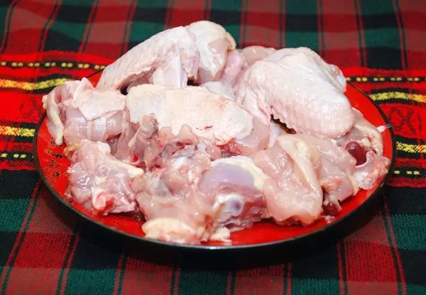 Hakket på stykkerne rå kylling på en plade