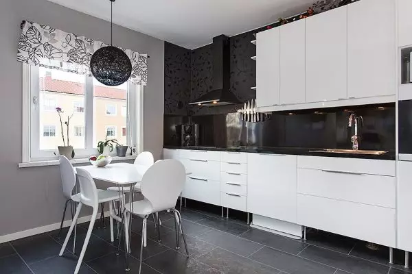 Črna stena in belo pohištvo v kuhinji