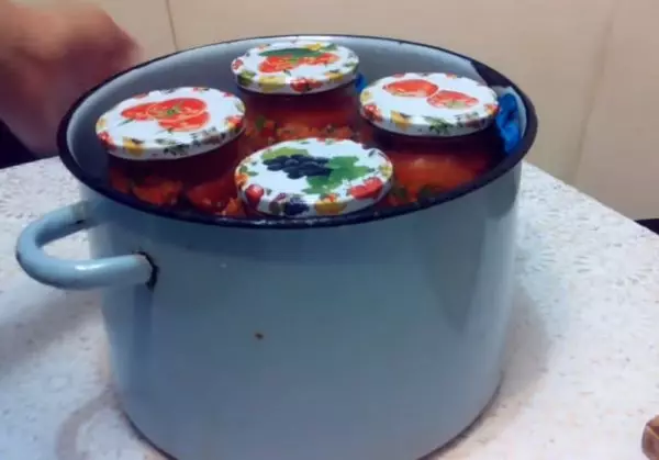 Banken met tomaten staan ​​in een pan