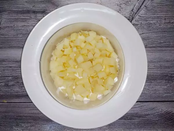 Molding ring with chopped boiled potatoes on a plate