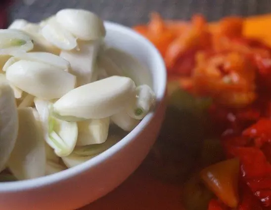 淨化的大蒜丁香在一個碗里和切碎的豆莢紅辣椒