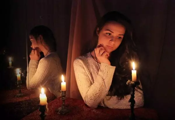 Κορίτσι με ένα κερί μπροστά από έναν καθρέφτη