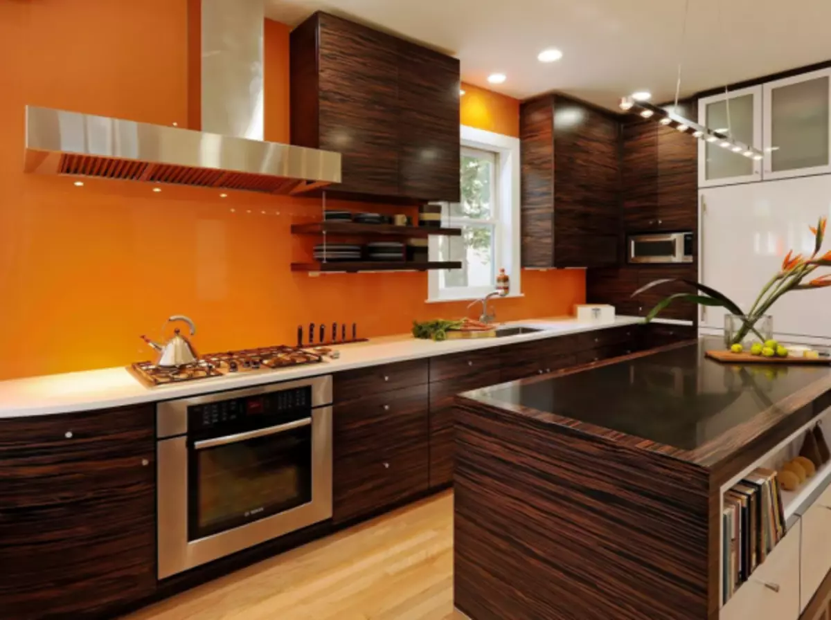 Brune møbler og oransje vegg på kjøkkenet