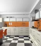 Masakan dengan apron oren dan lantai kontras