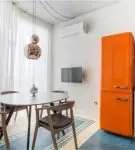 Oransje kjøleskap i lakonisk kjøkken interiør